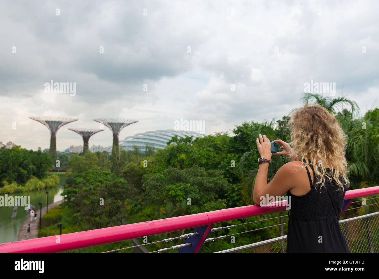 A woman take photos with her phone of the solar powered supertrees on ...