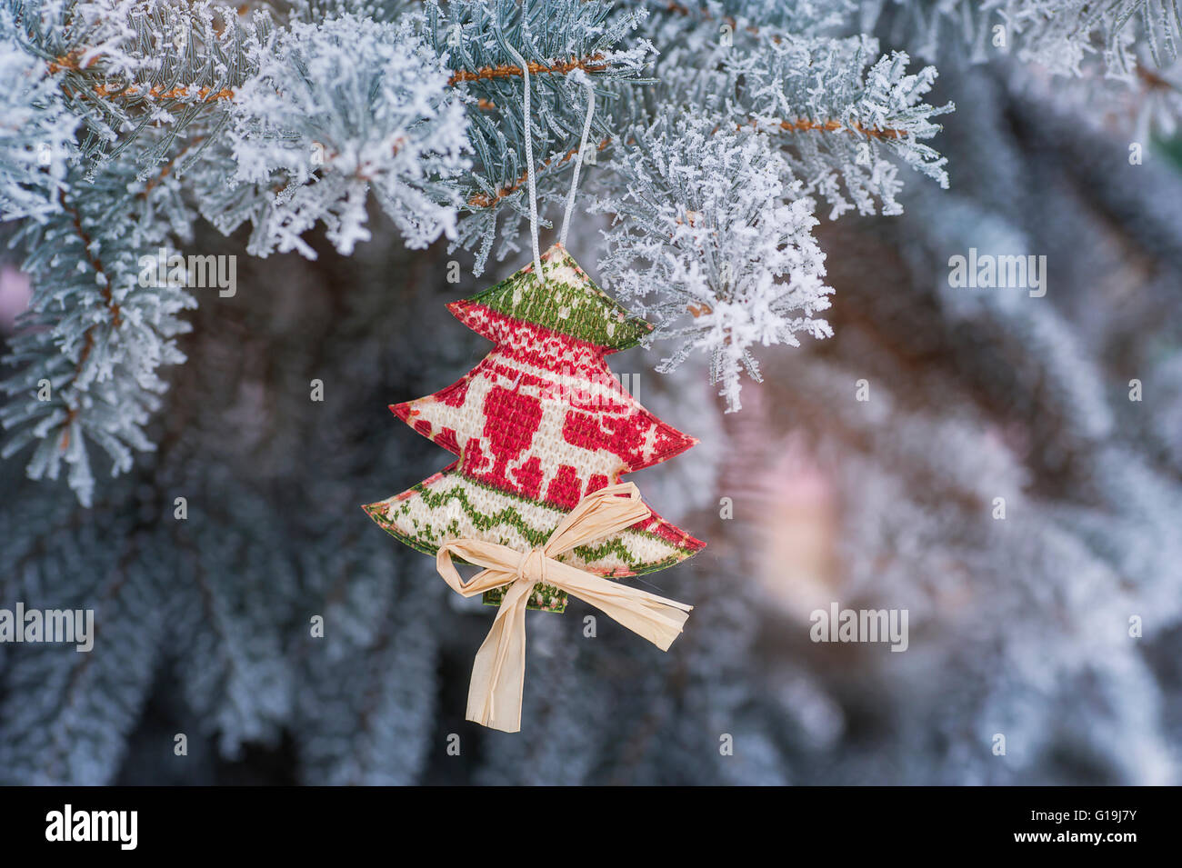 on a snowy tree branch hanging Christmas toy handmade Stock Photo - Alamy