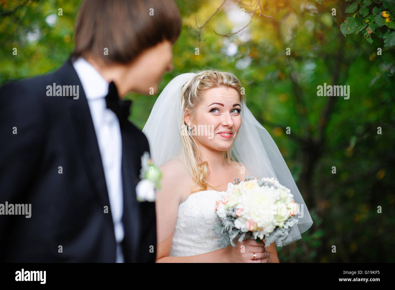 Beautiful bride looking over her shoulder and smiling Stock Photo - Alamy