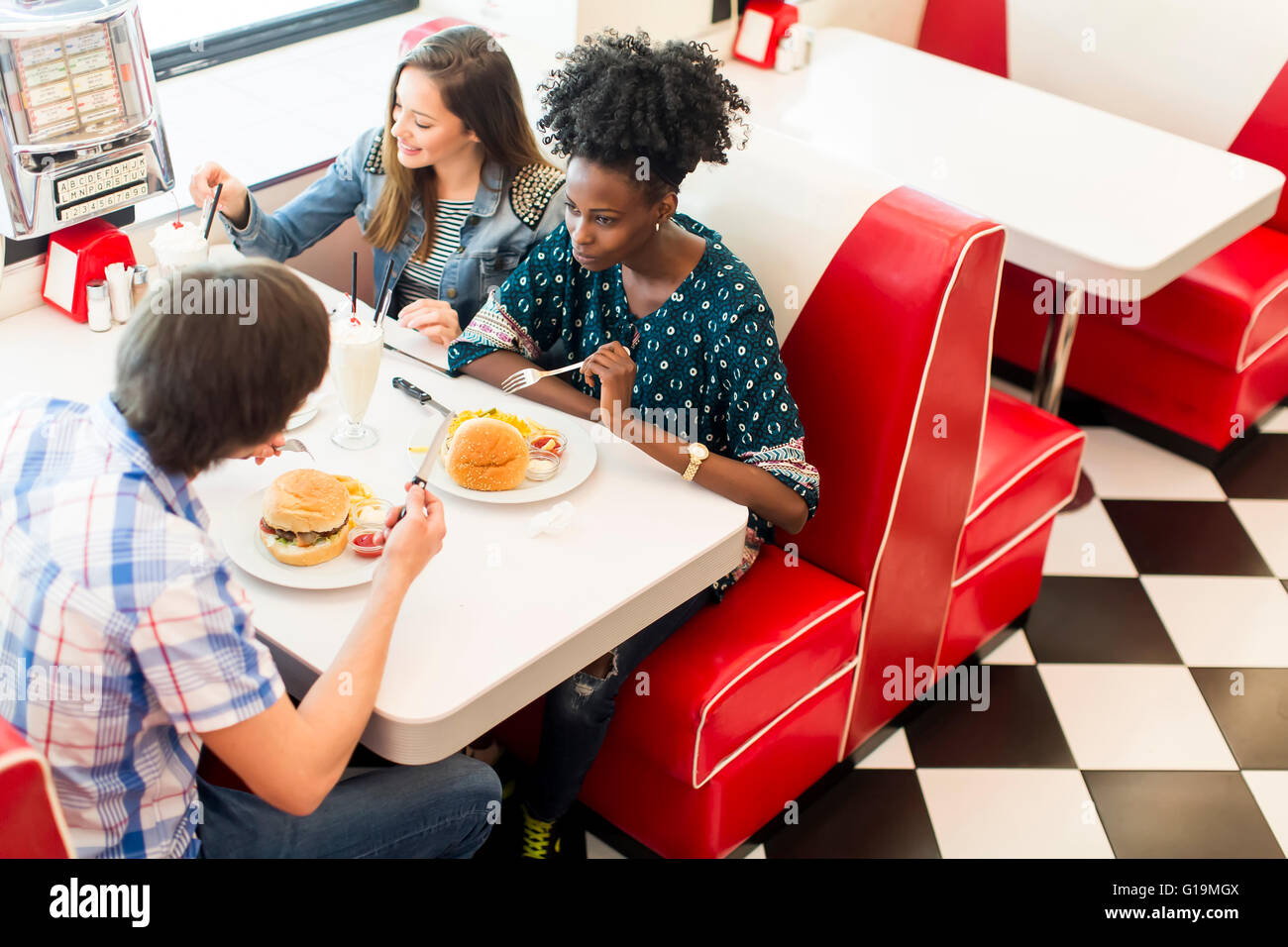 Friends eating at the table in the diner Stock Photo - Alamy