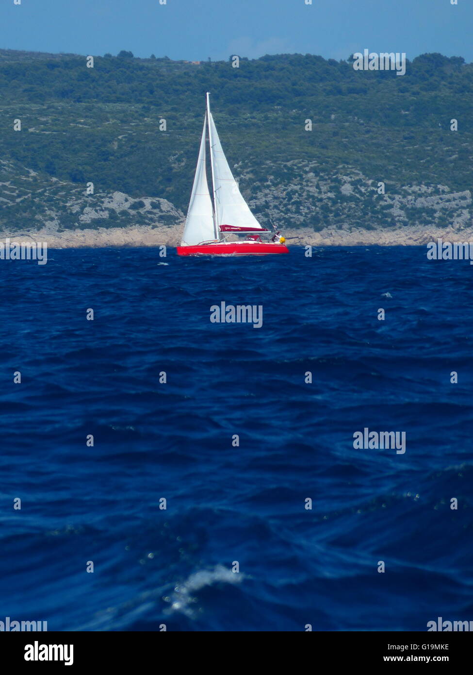 Smaller sail boat negotiates choppy seas Stock Photo - Alamy
