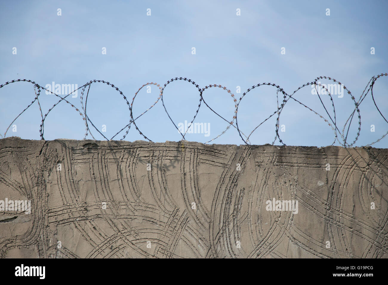 Barbed wire on top of prison wall Stock Photo - Alamy