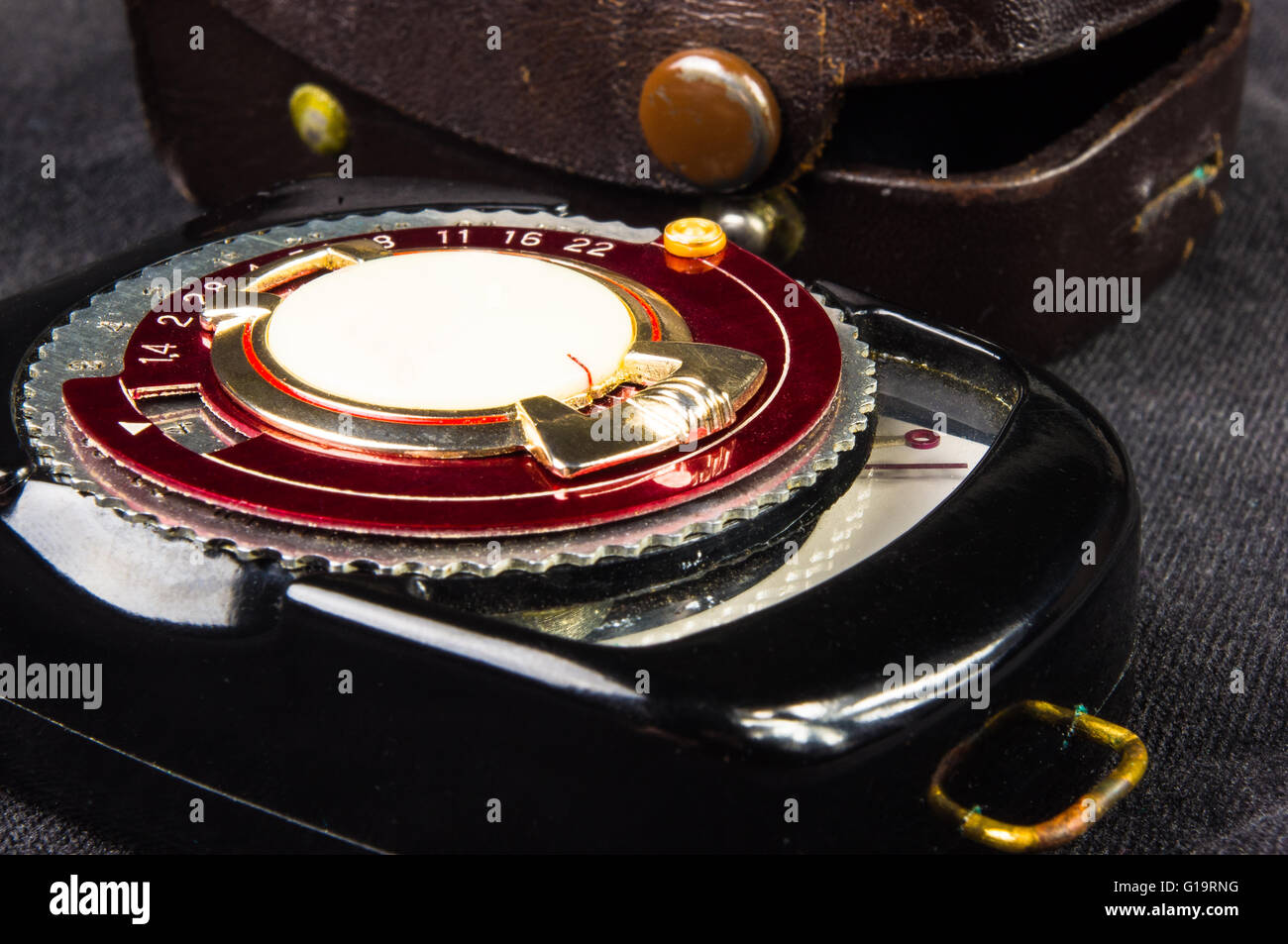 old vintage Soviet exposure meter with leather case on black background ...