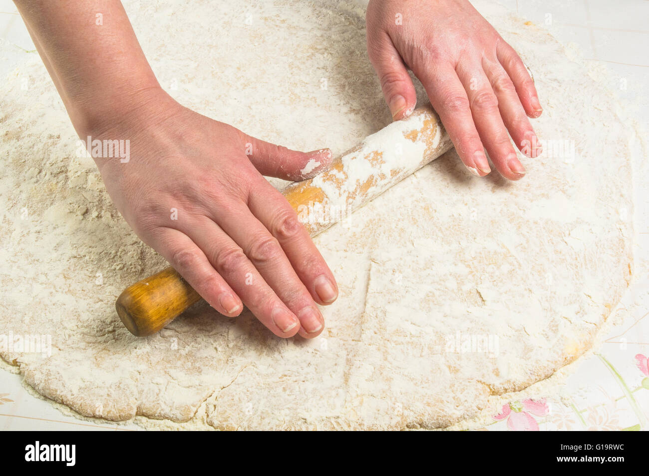 making homemade sugar cookies - woman's hands, rolling pin a dough and ...