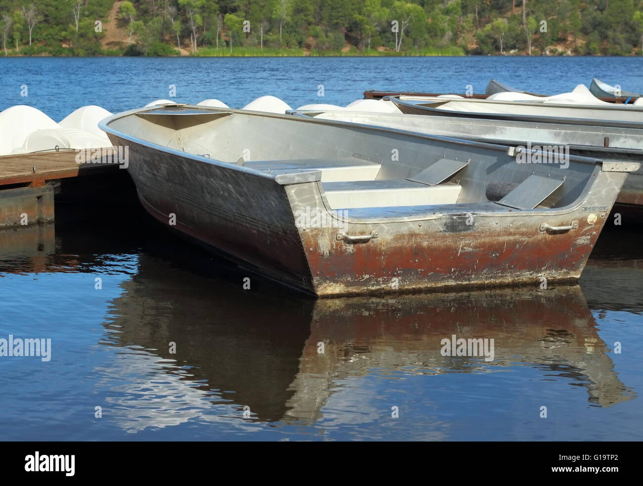 Old Row Boat in water tied to dock Stock Photo - Alamy