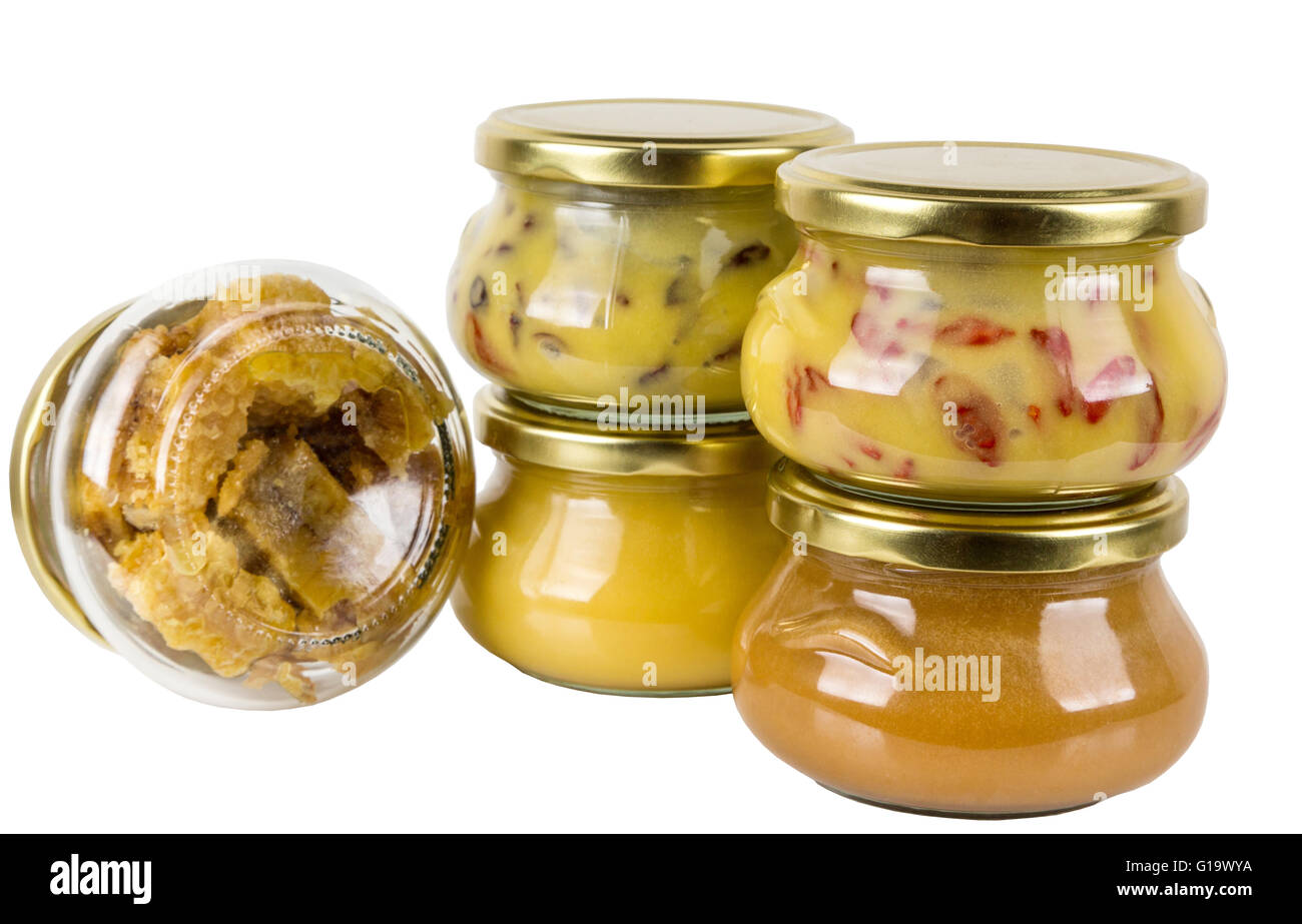 five closed cans with different honey of yellow and brown colors and ...