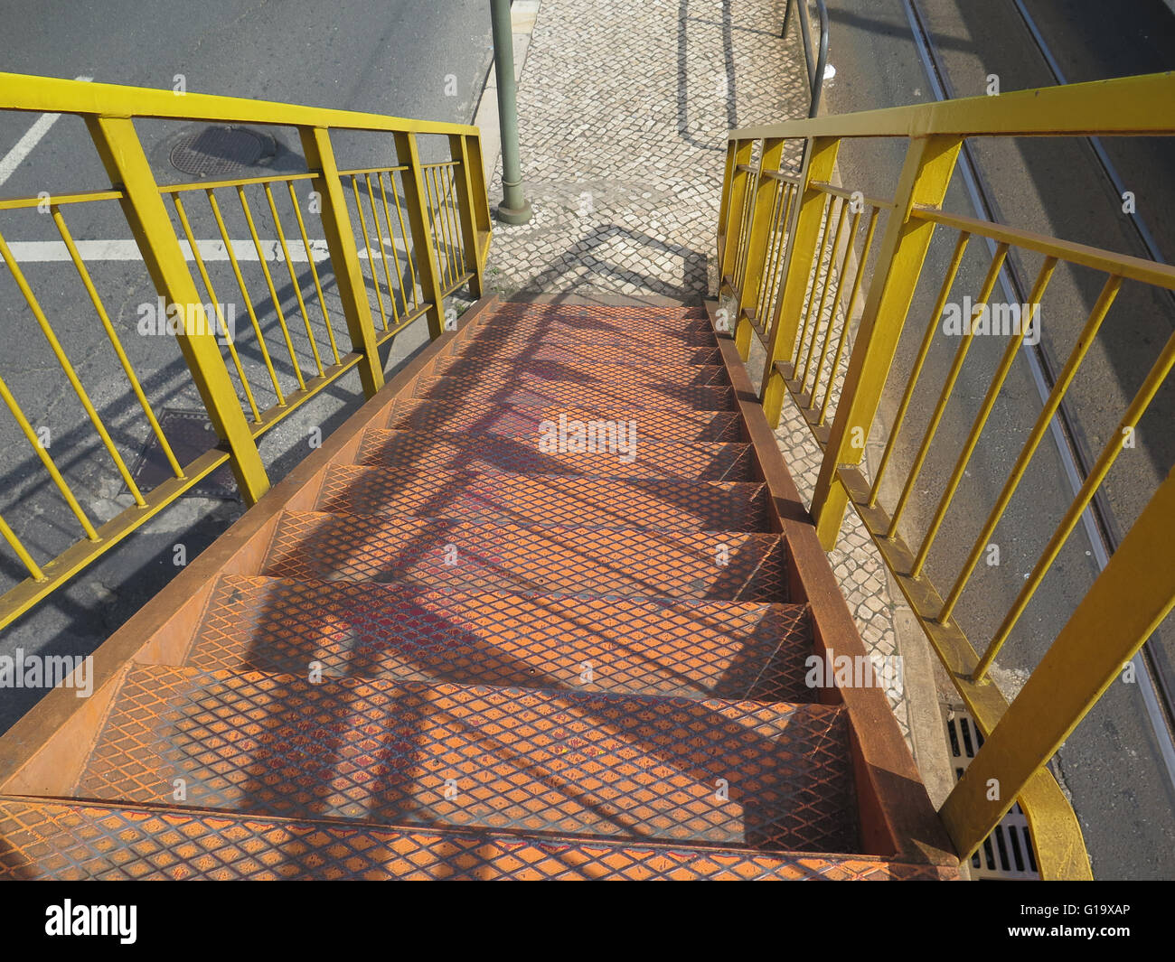 Yellow Steel stairs and railing leading down from road and rail ...
