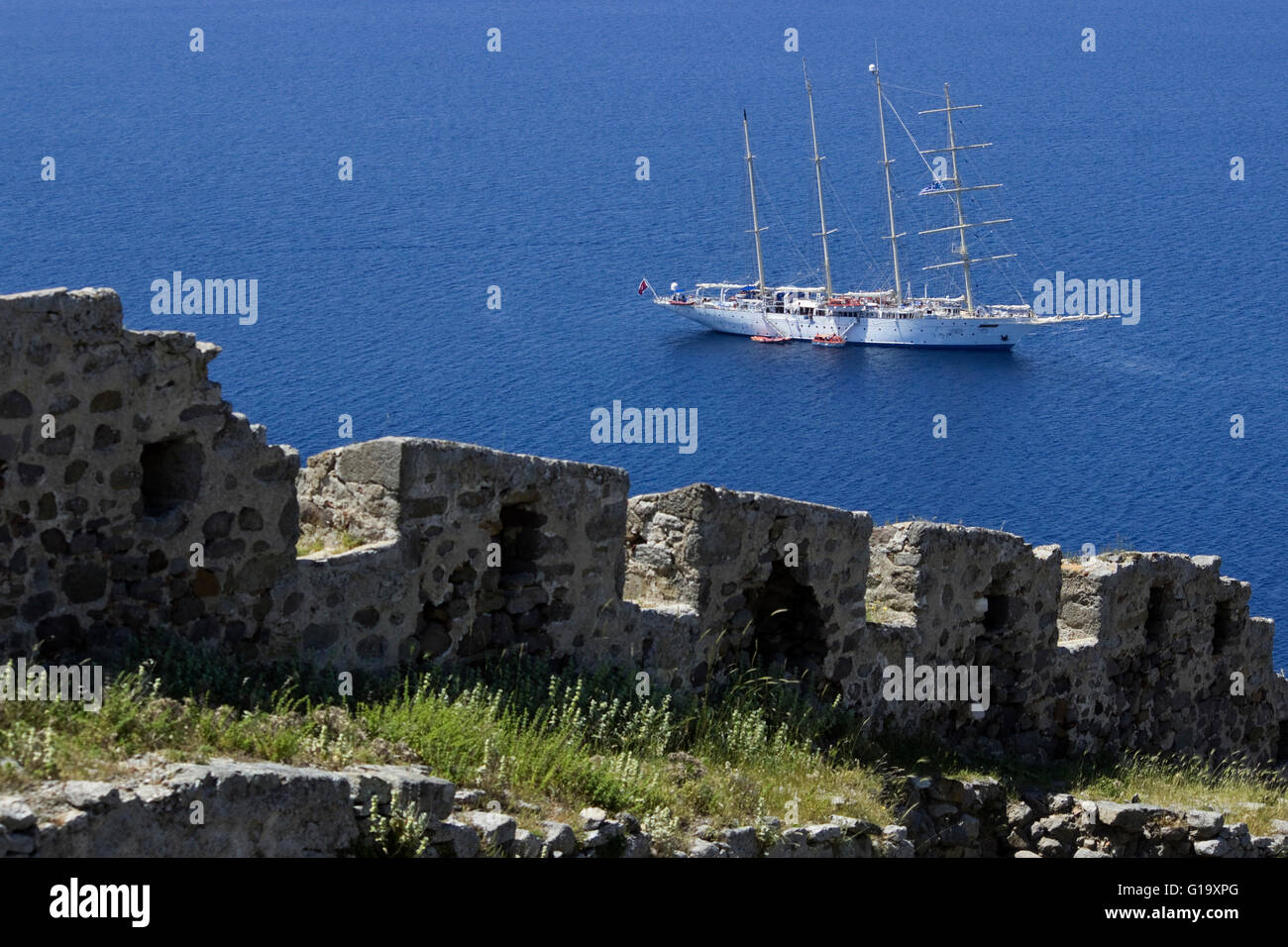 Myrina's medieval crenellated castle walls and the anchored luxurious ...
