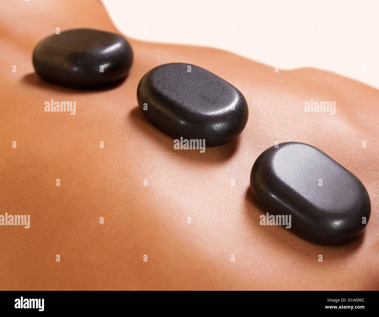 Part of woman back with black stones Stock Photo - Alamy