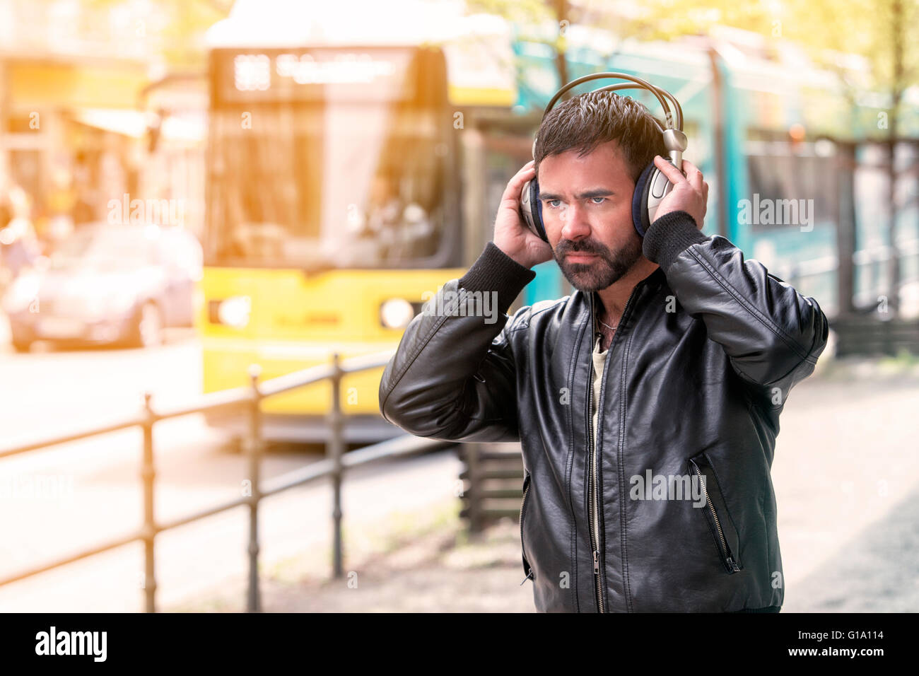 young man standing with headphones in the street Stock Photo - Alamy
