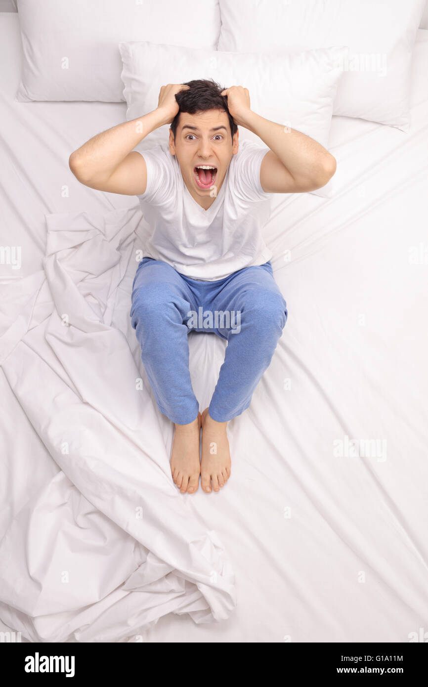 Vertical shot of an angry man suffering from insomnia and screaming ...