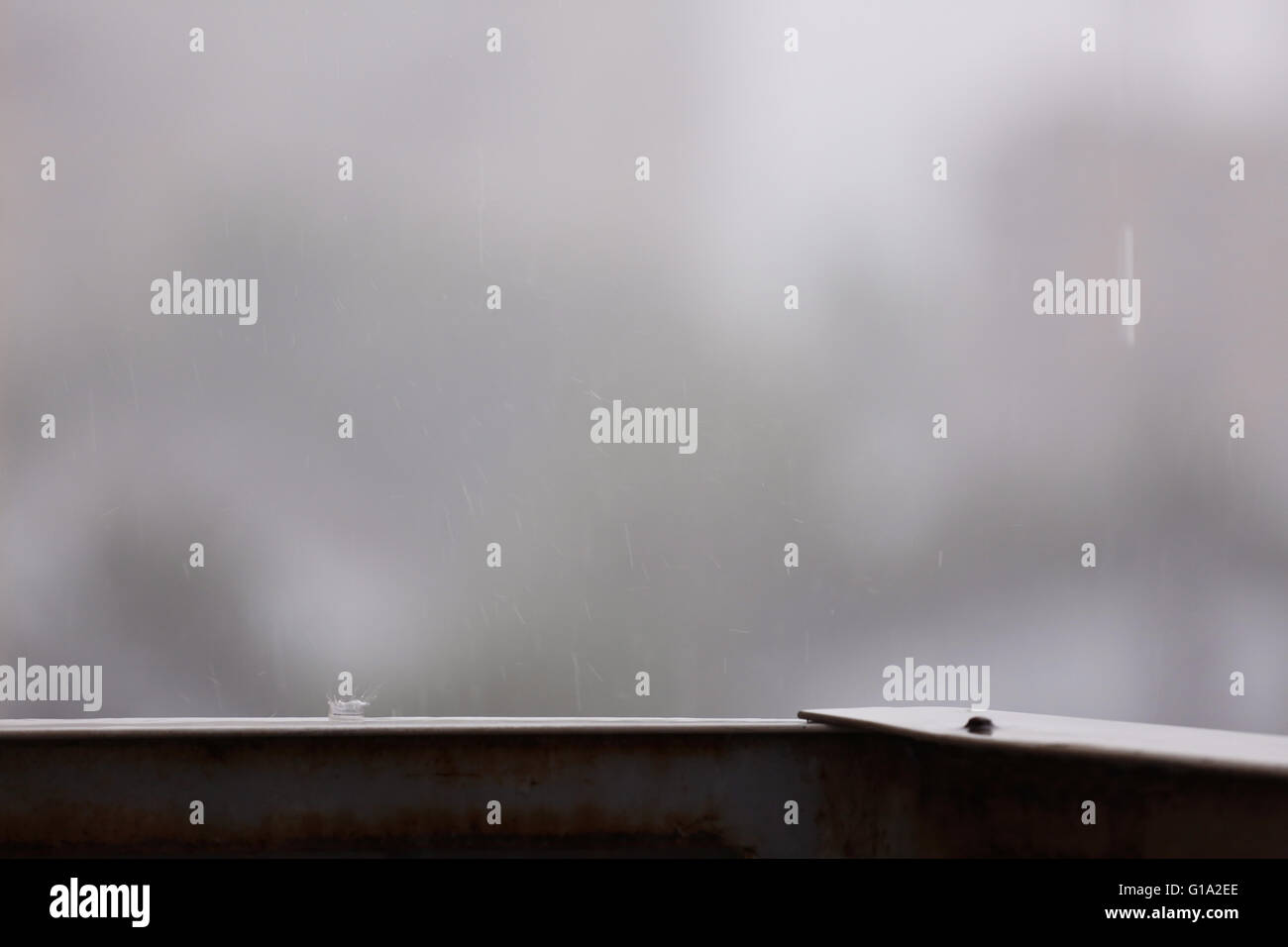 Heavy rain drops falling down at balcony fence Stock Photo - Alamy