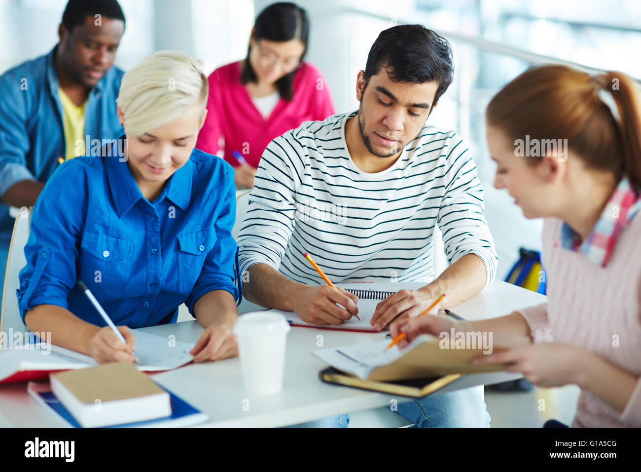 Ethnic college students writing hi-res stock photography and images - Alamy