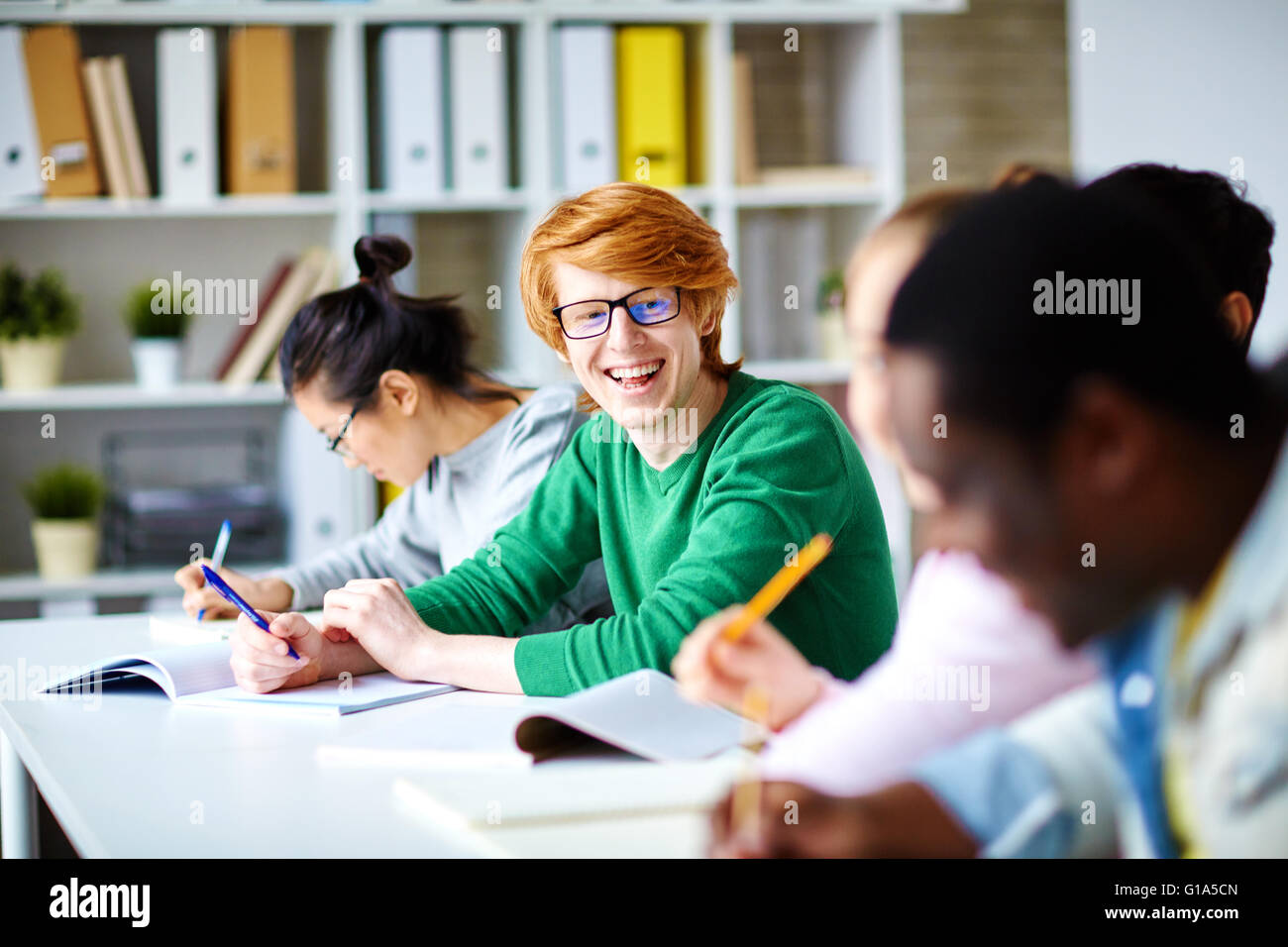 Laughing student looking at his friends during lecture Stock Photo - Alamy