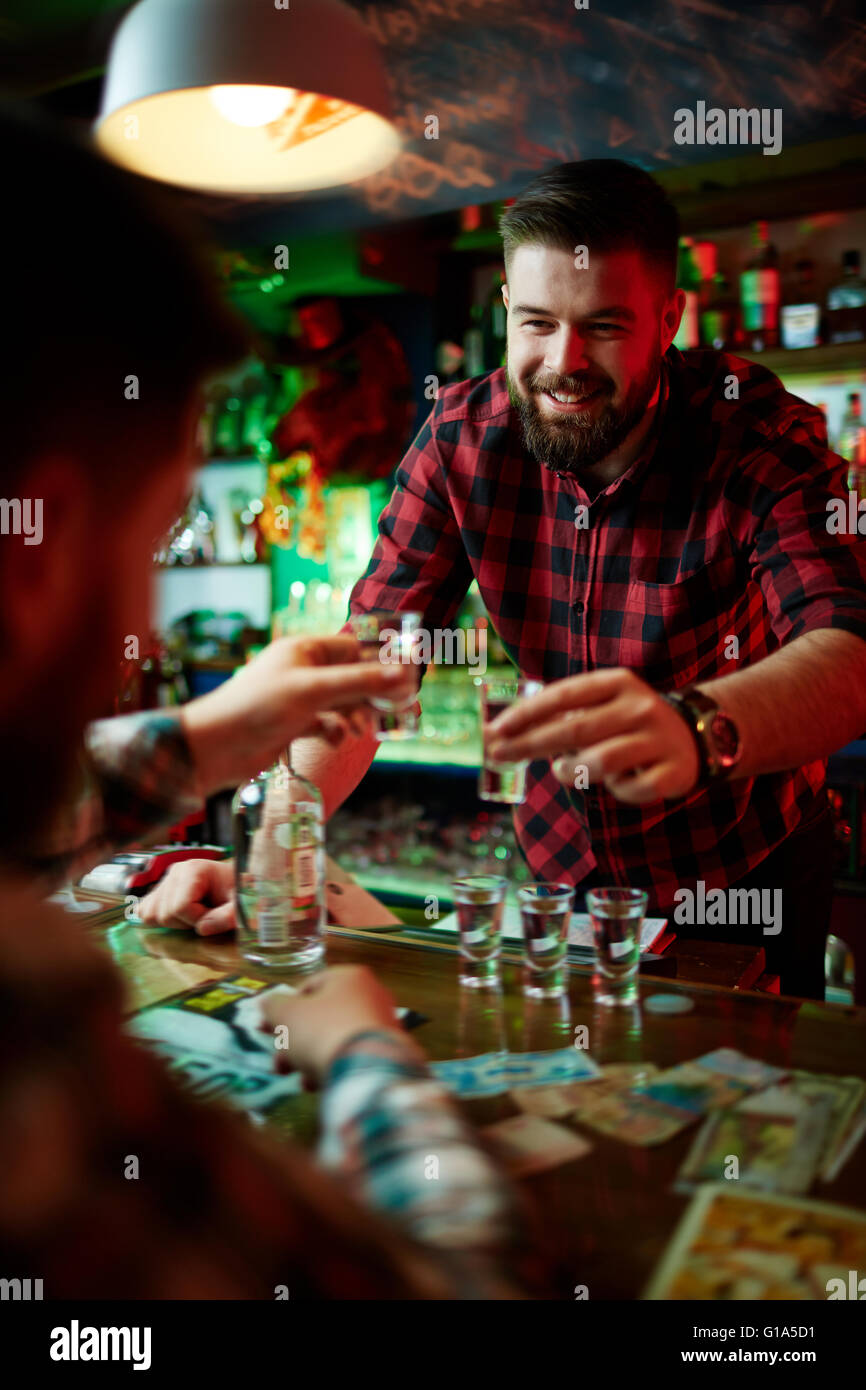 Happy barman and guy toasting with vodka over bar counter Stock Photo ...