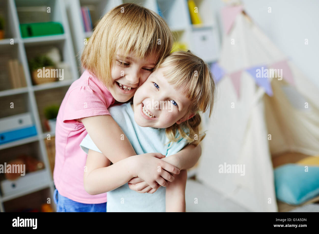 Adorable girl embracing her sister Stock Photo - Alamy
