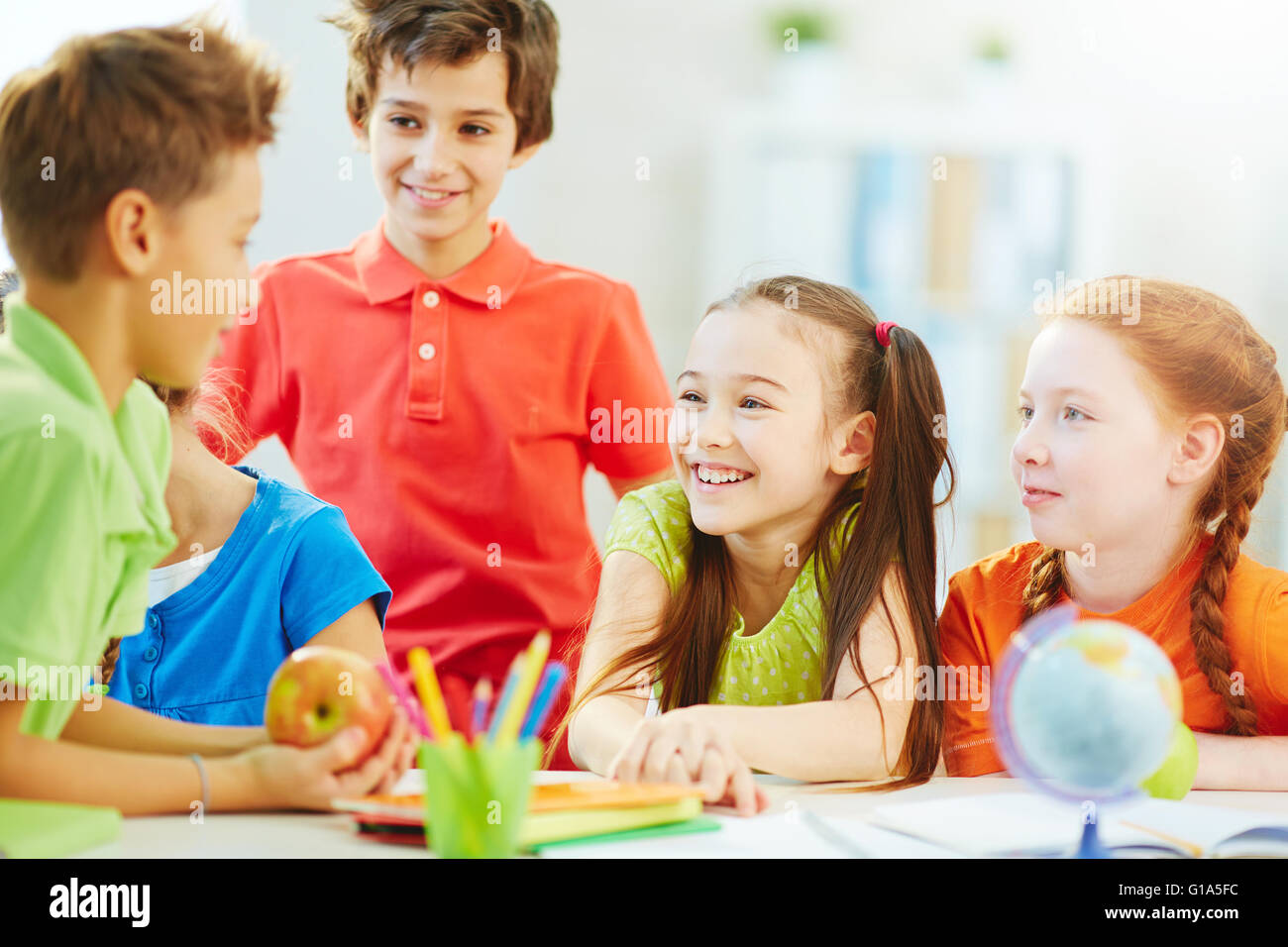 Happy classmates talking at break in school Stock Photo - Alamy