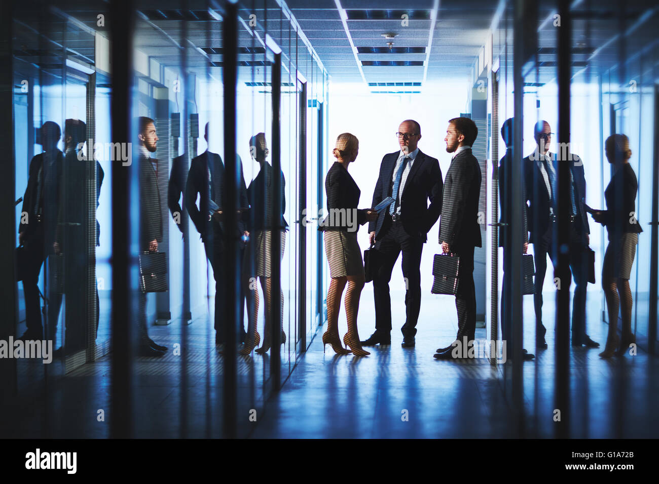 Discussing work in corridor Stock Photo - Alamy