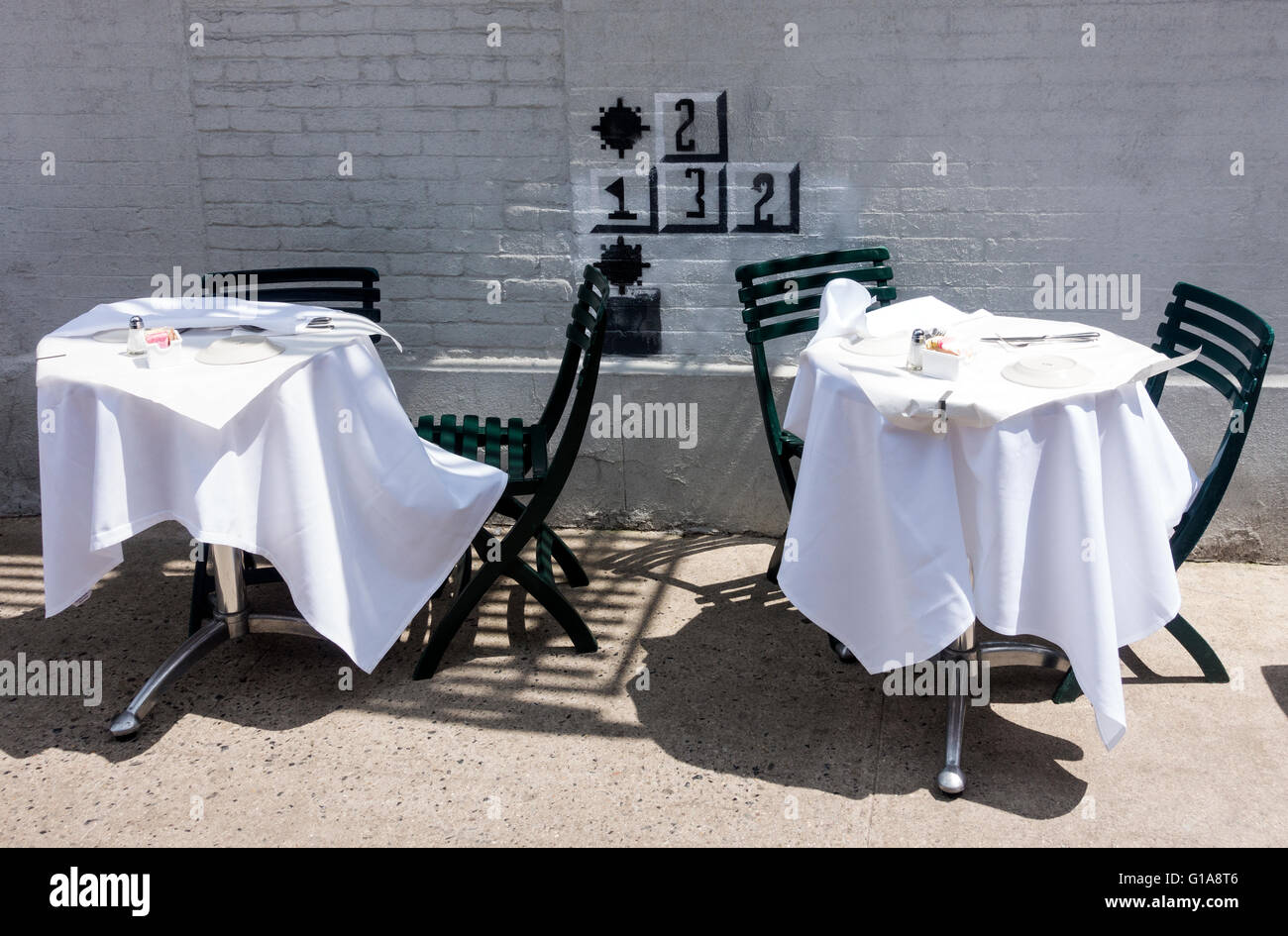 White linen tables cloths await customers at outside tables of a ...