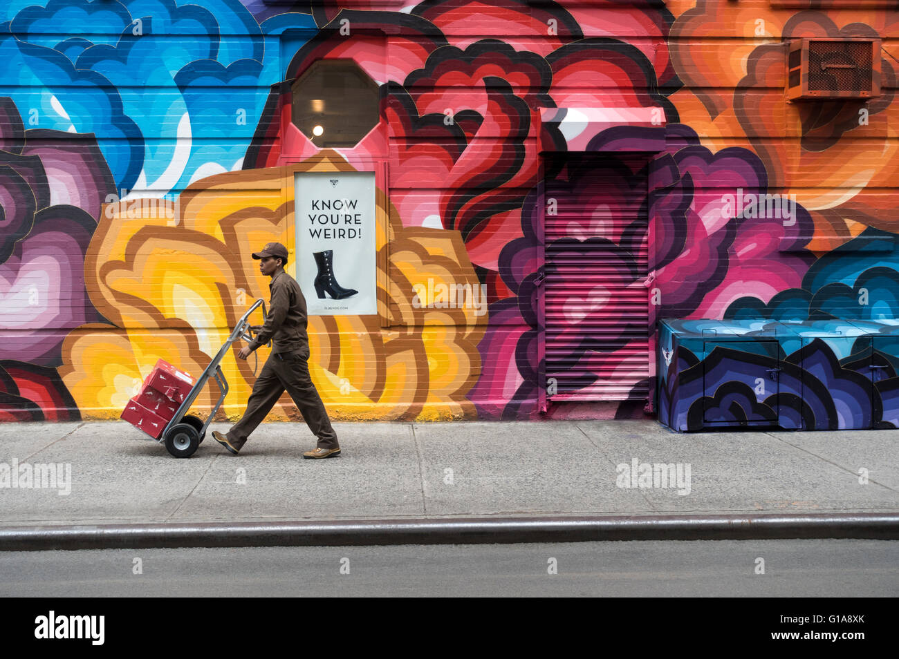 Female African-American UPS delivery worker pushing packages past ...