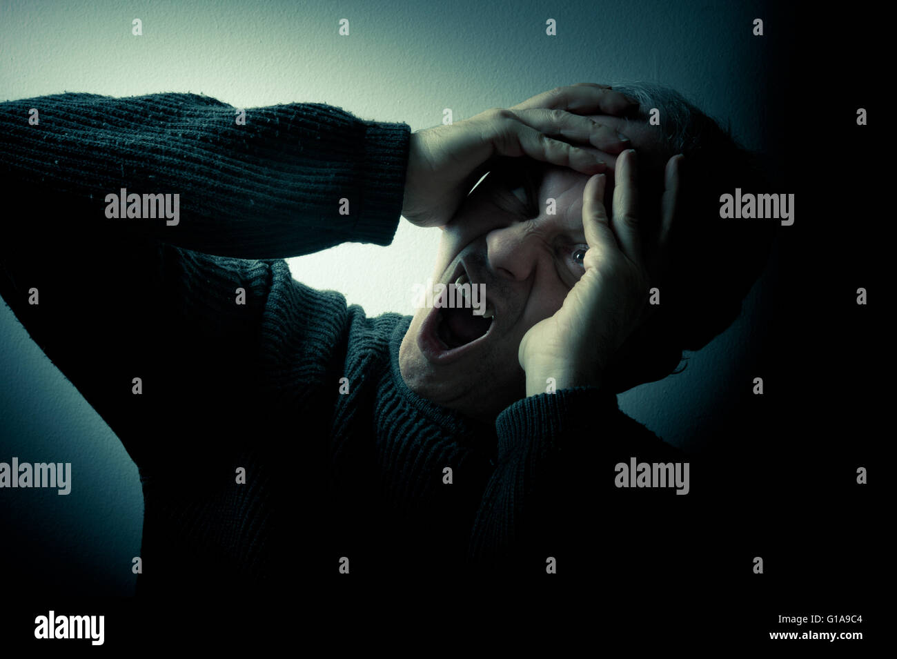 man with hands on his head screaming, concept for madness and insanity ...