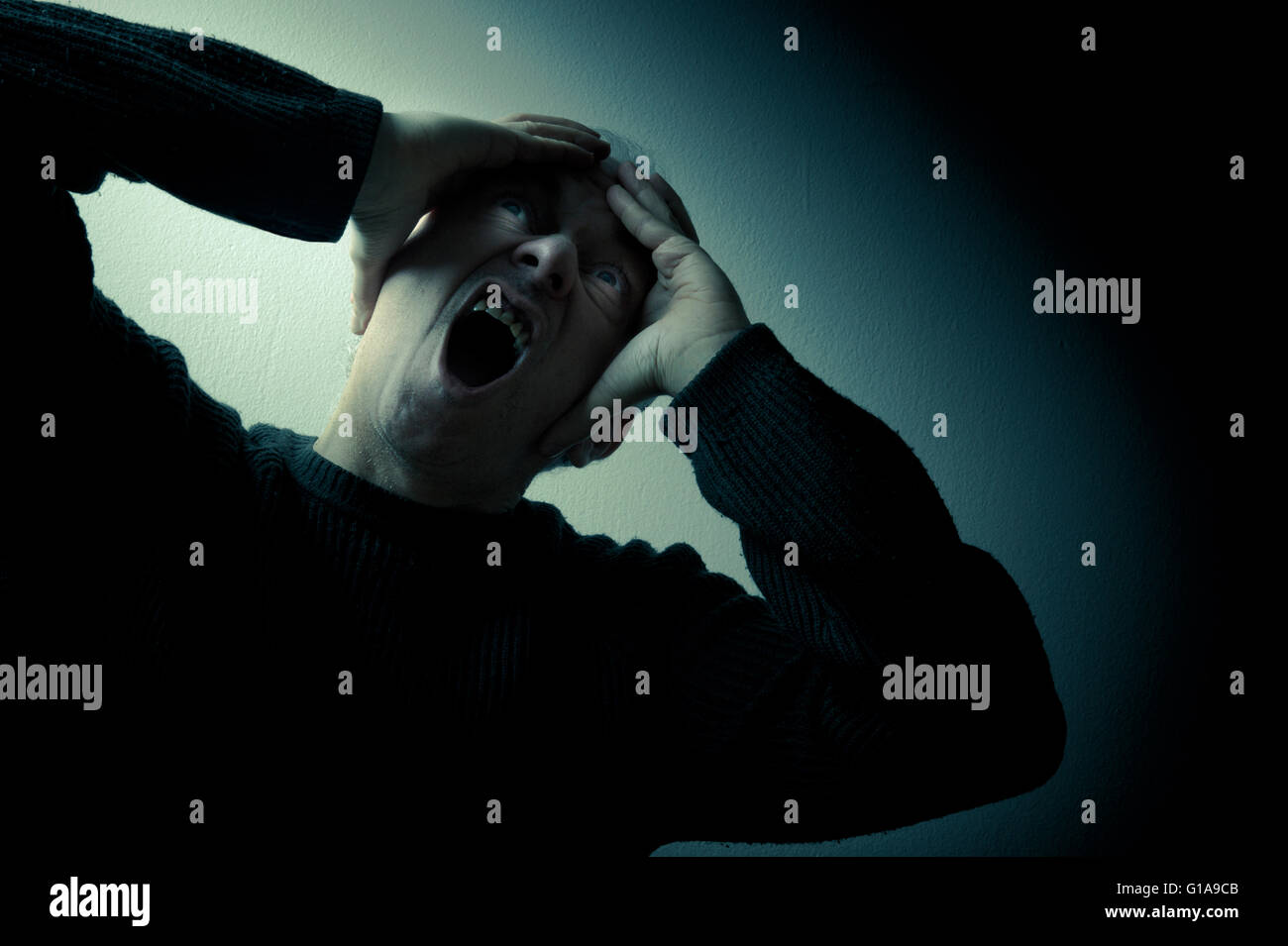 Man With Hands On His Head Screaming Concept For Madness And Insanity