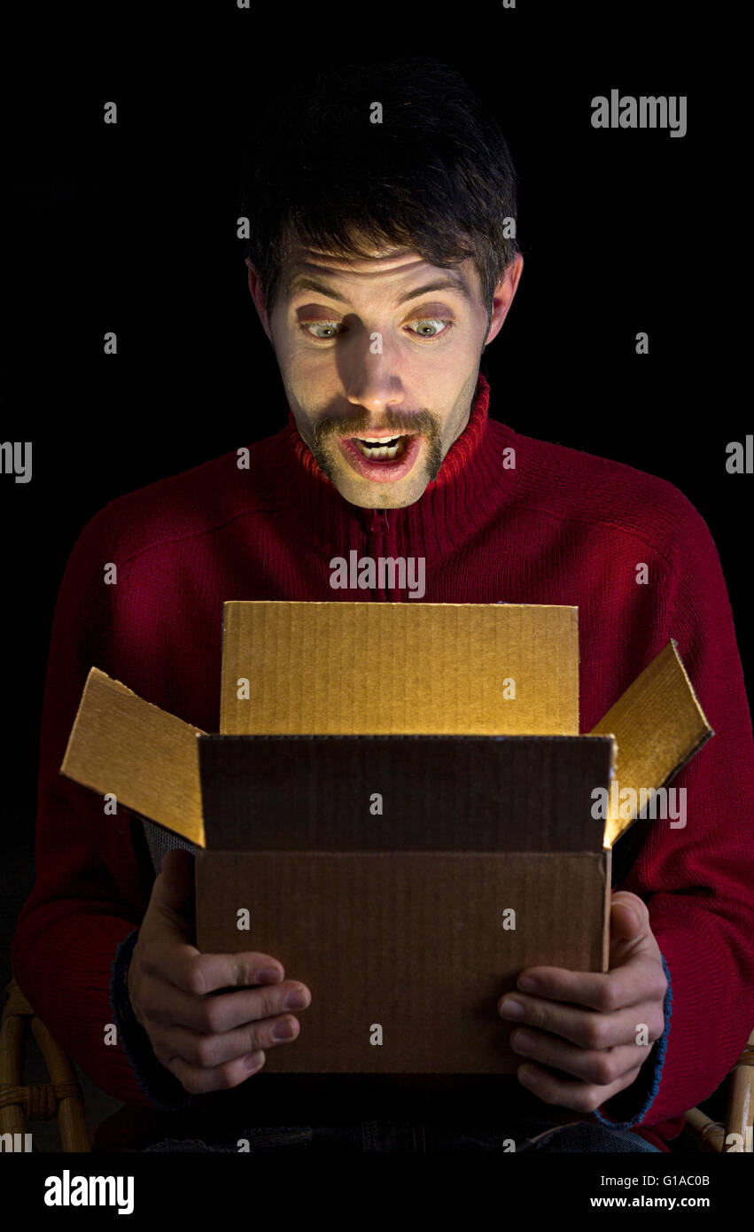man opening box with surprised face Stock Photo - Alamy