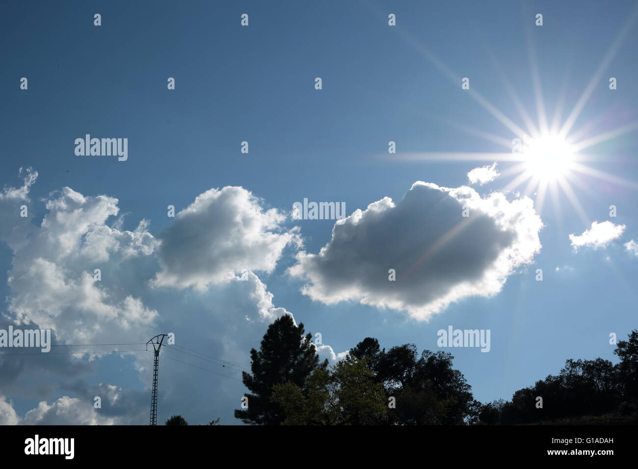 Green landscape with clouds and sun front Stock Photo - Alamy