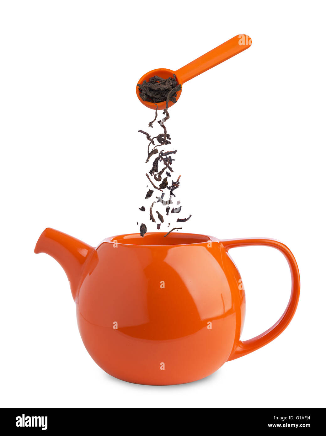 dry black tea falling from a spoon into teapot isolated on white Stock ...