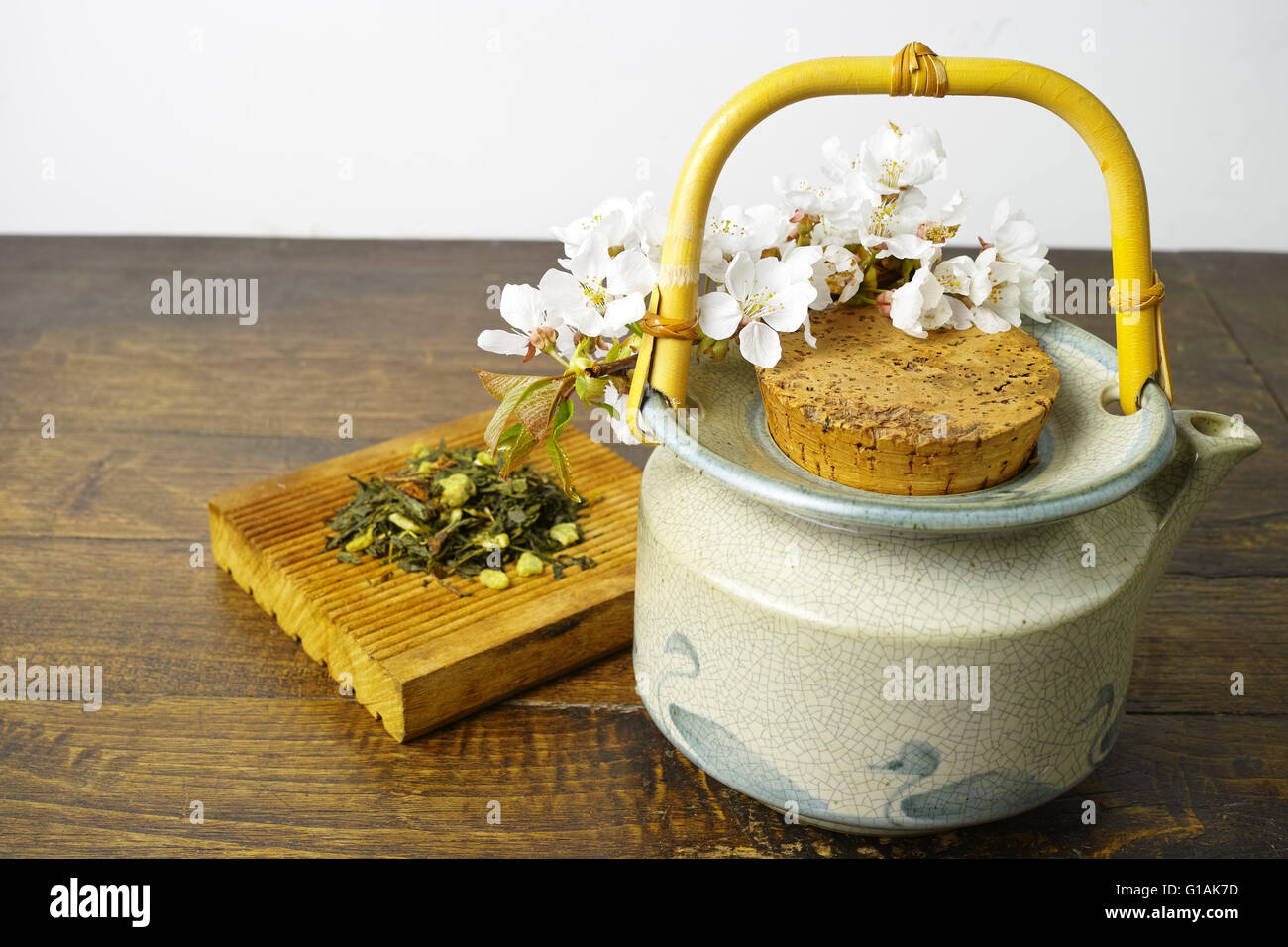 Japan's teapot with green tea on wooden plank and sakura flowers on ...