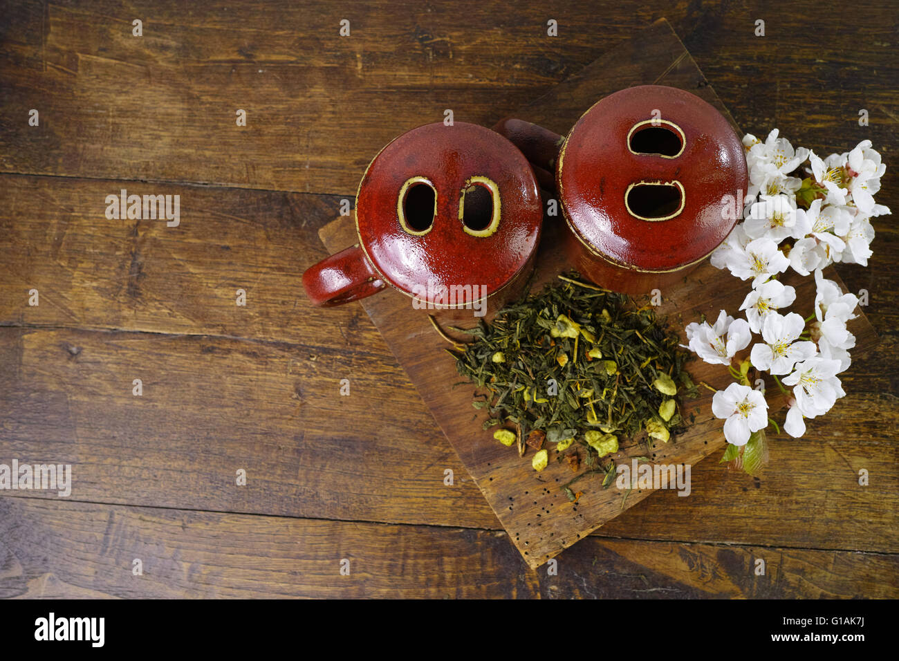 Japan's tea cups with green tea on wooden plank and sakura flowers on ...