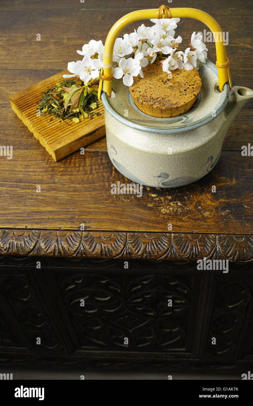 Japan's teapot with green tea on wooden plank and sakura flowers on ...