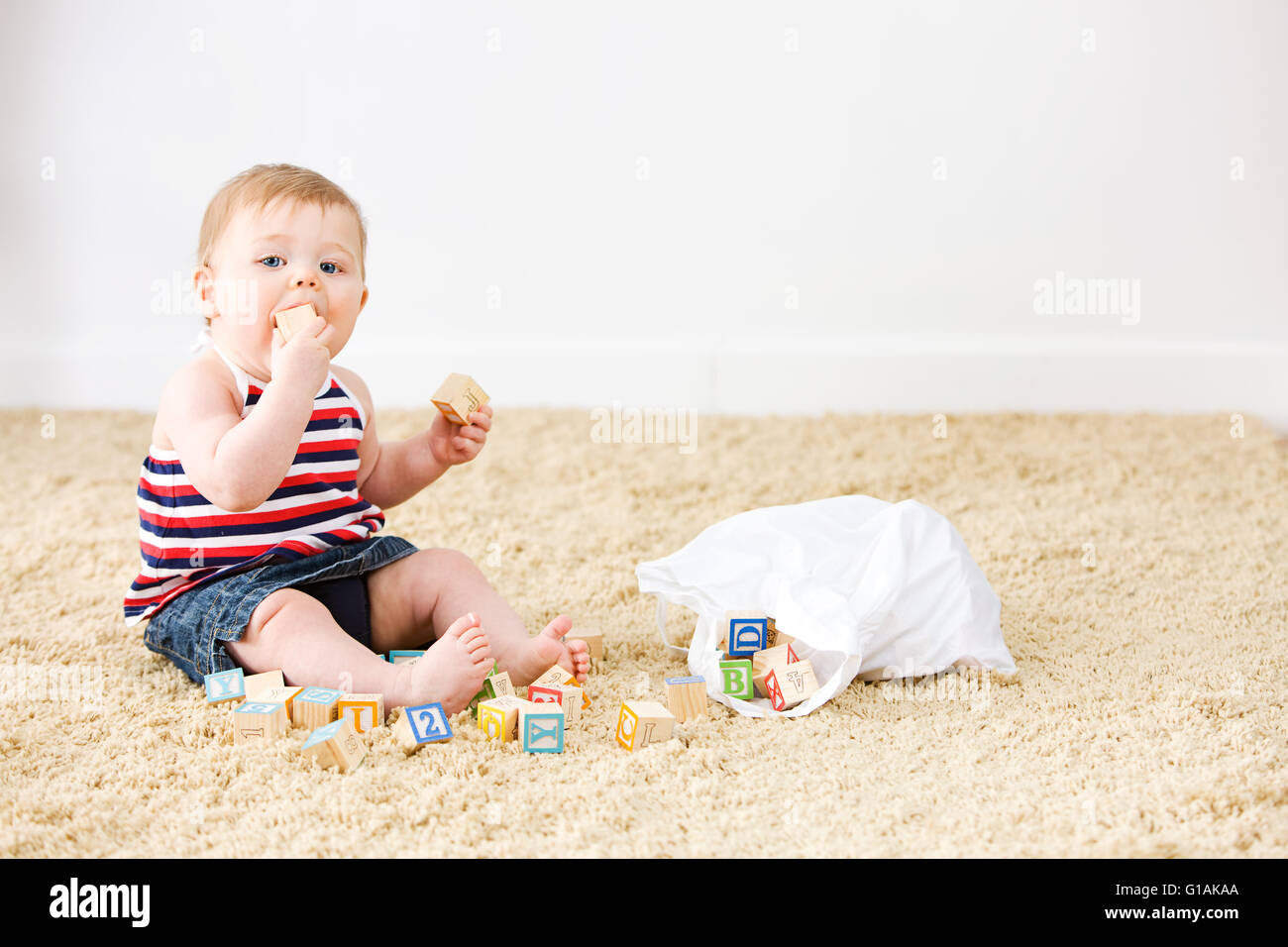 Cute Caucasian baby, on carpet, indoors, with various props Stock Photo ...