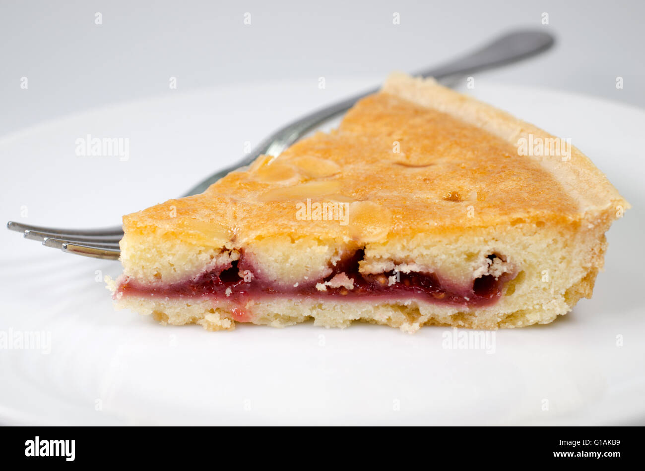 Slice of bakewell tart on plate with fork Stock Photo - Alamy
