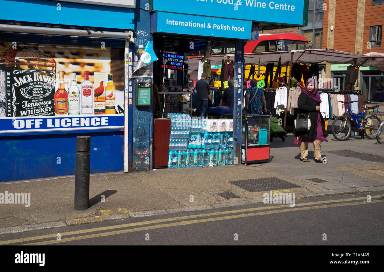 Muslim woman walks past an off-license alcohol shop in Whitechapel ...