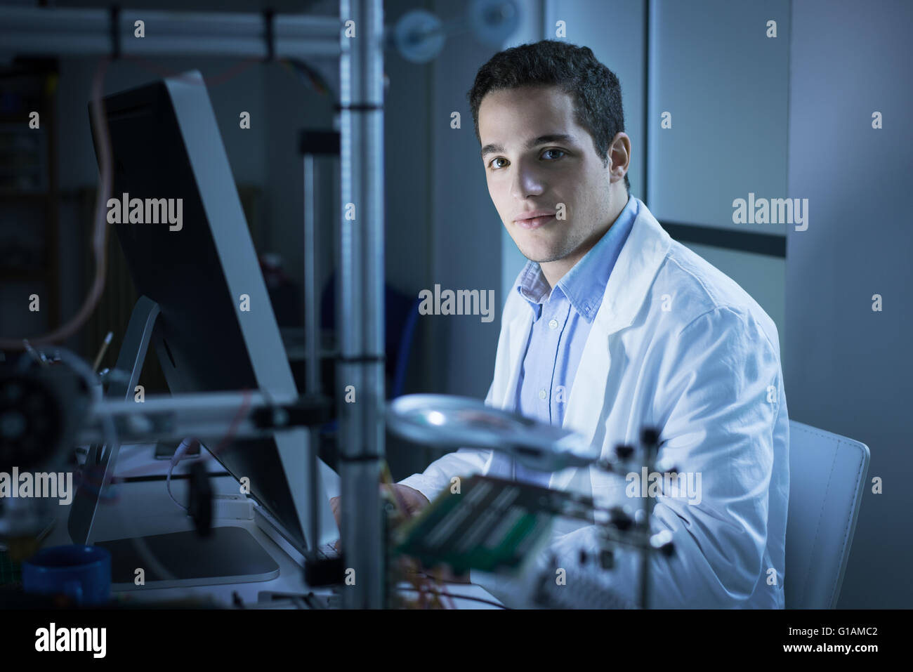 Young researcher in the lab, wearing a lab coat and working with a ...
