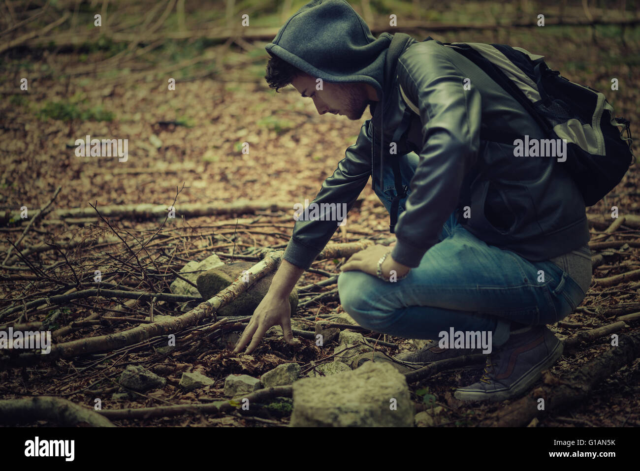 Man in the forest exploring and searching for tracks, adventure and ...