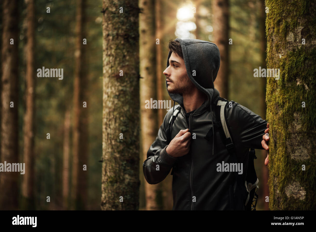 Young handsome man walking in a forest and looking around, nature and ...