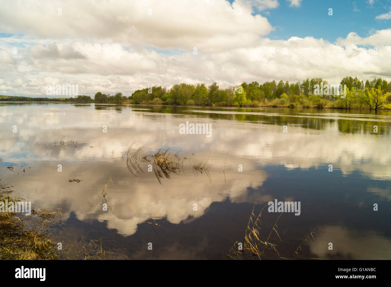 Spring landscape with river on background beautiful sky and reflections ...