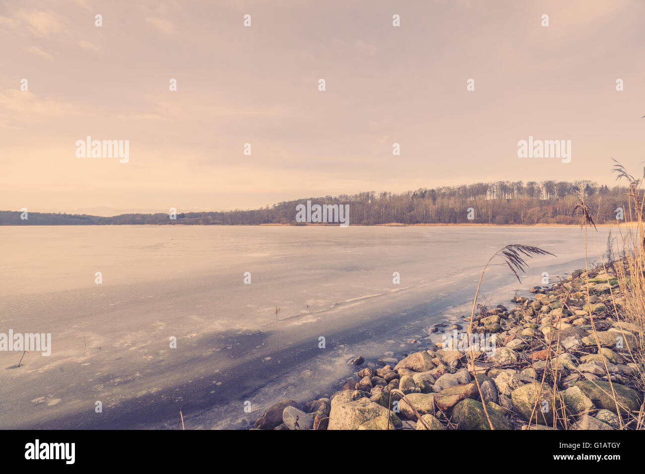 Frozen river landscape with pebbles in the winter Stock Photo - Alamy