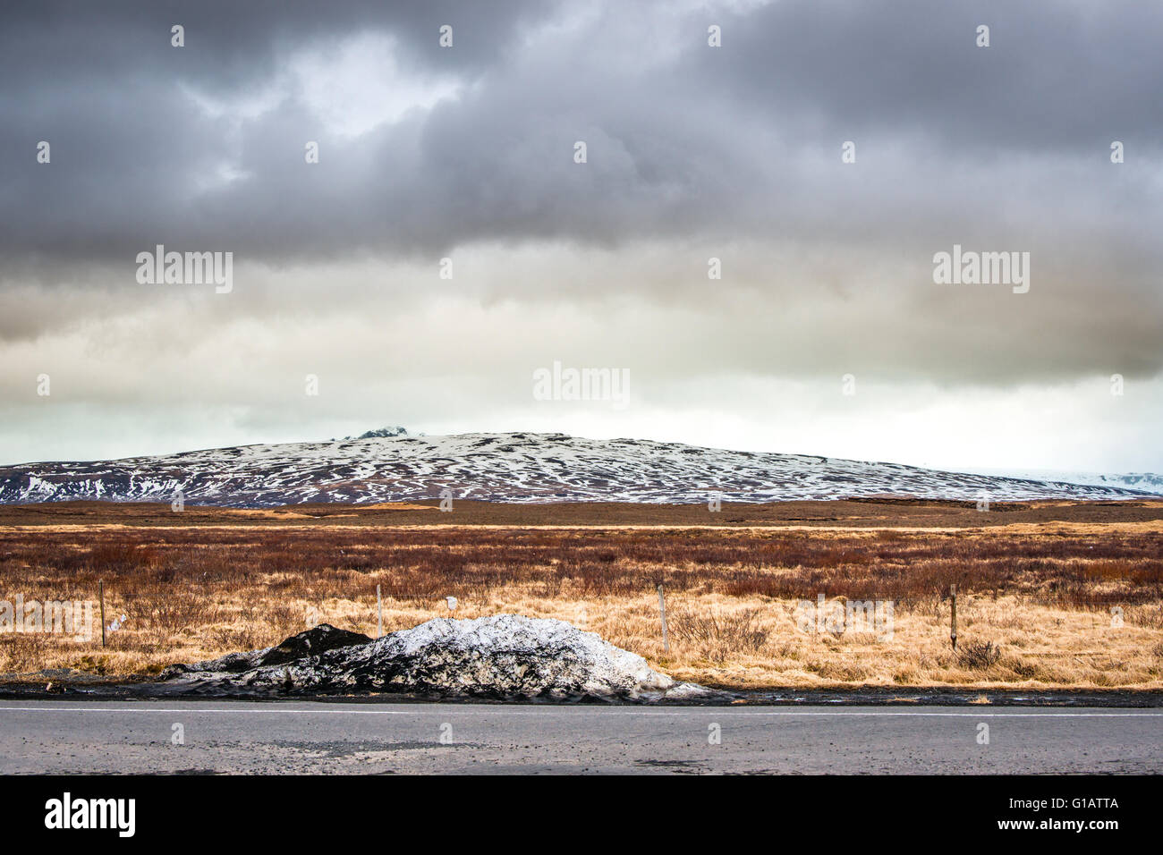 Snow by a road in dramatic scenery with cloudy weather Stock Photo - Alamy