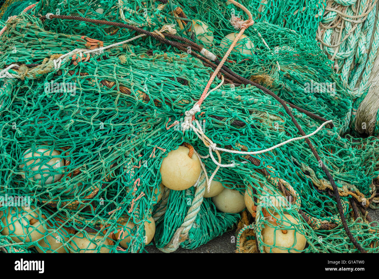 Messy green fishing net by a harbor Stock Photo - Alamy