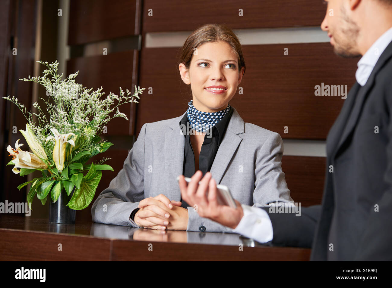 Friendly hotel receptionist and business guest at check-in Stock Photo ...
