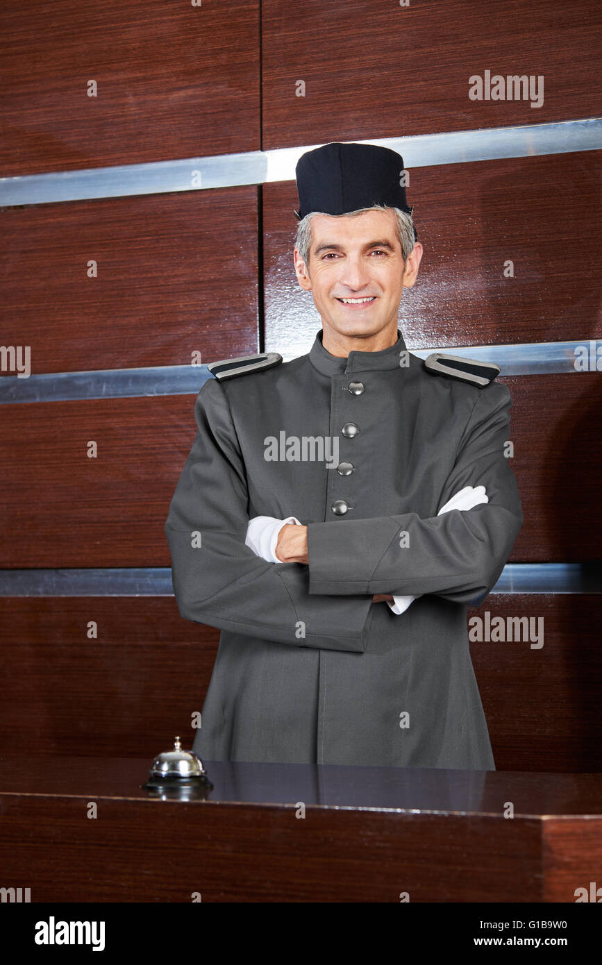 Friendly concierge in uniform at hotel reception with hotel bell Stock ...