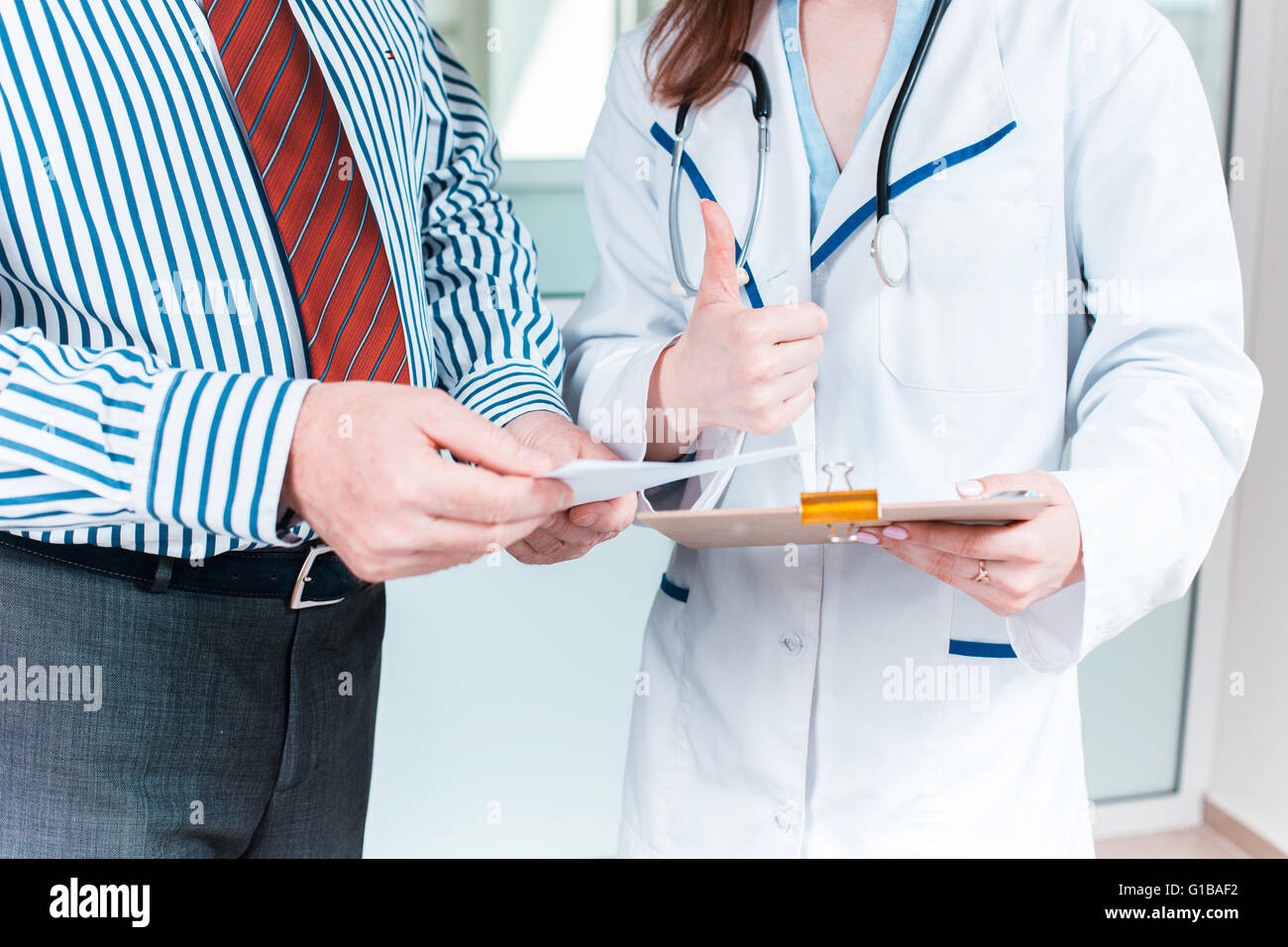 Close-up of doctor and patient hands holding papers with prescription ...