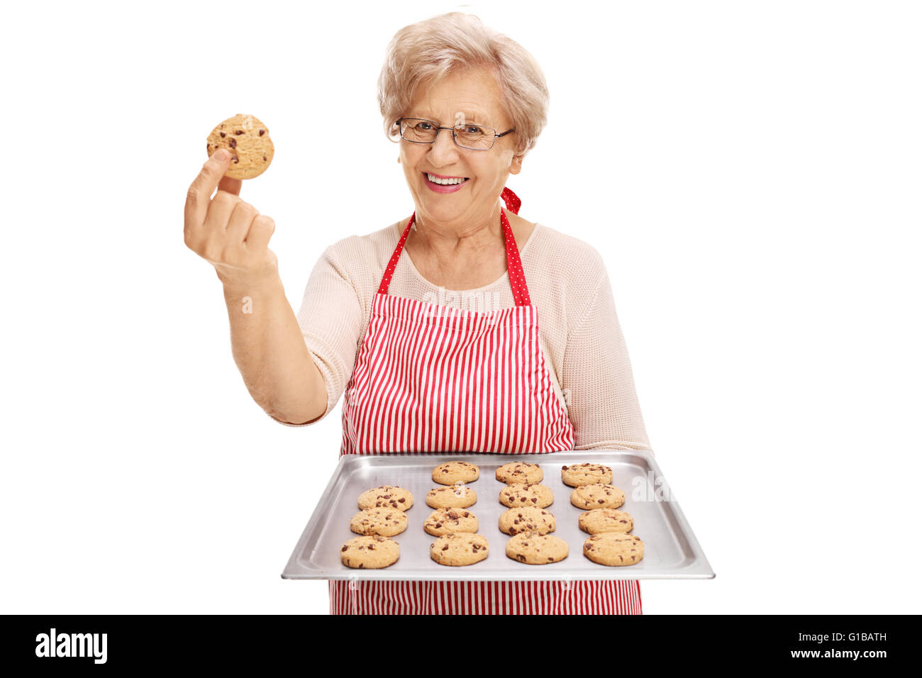 Cheerful senior lady giving chocolate chip cookies isolated on white ...