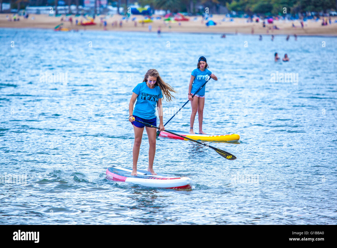 two girls doing Stand up paddle on the seaside Stock Photo - Alamy