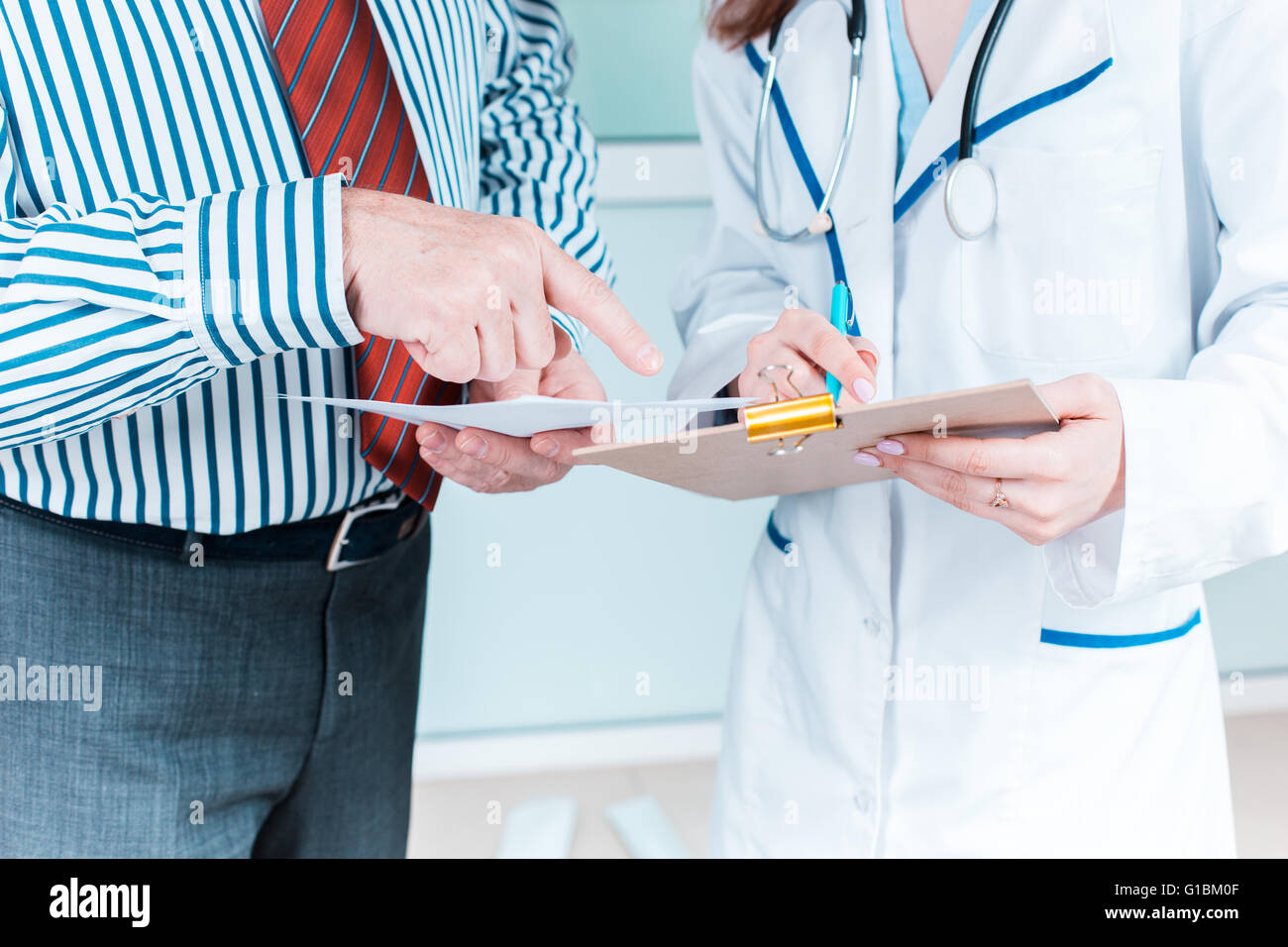 Close-up of doctor and patient hands holding papers with prescription ...