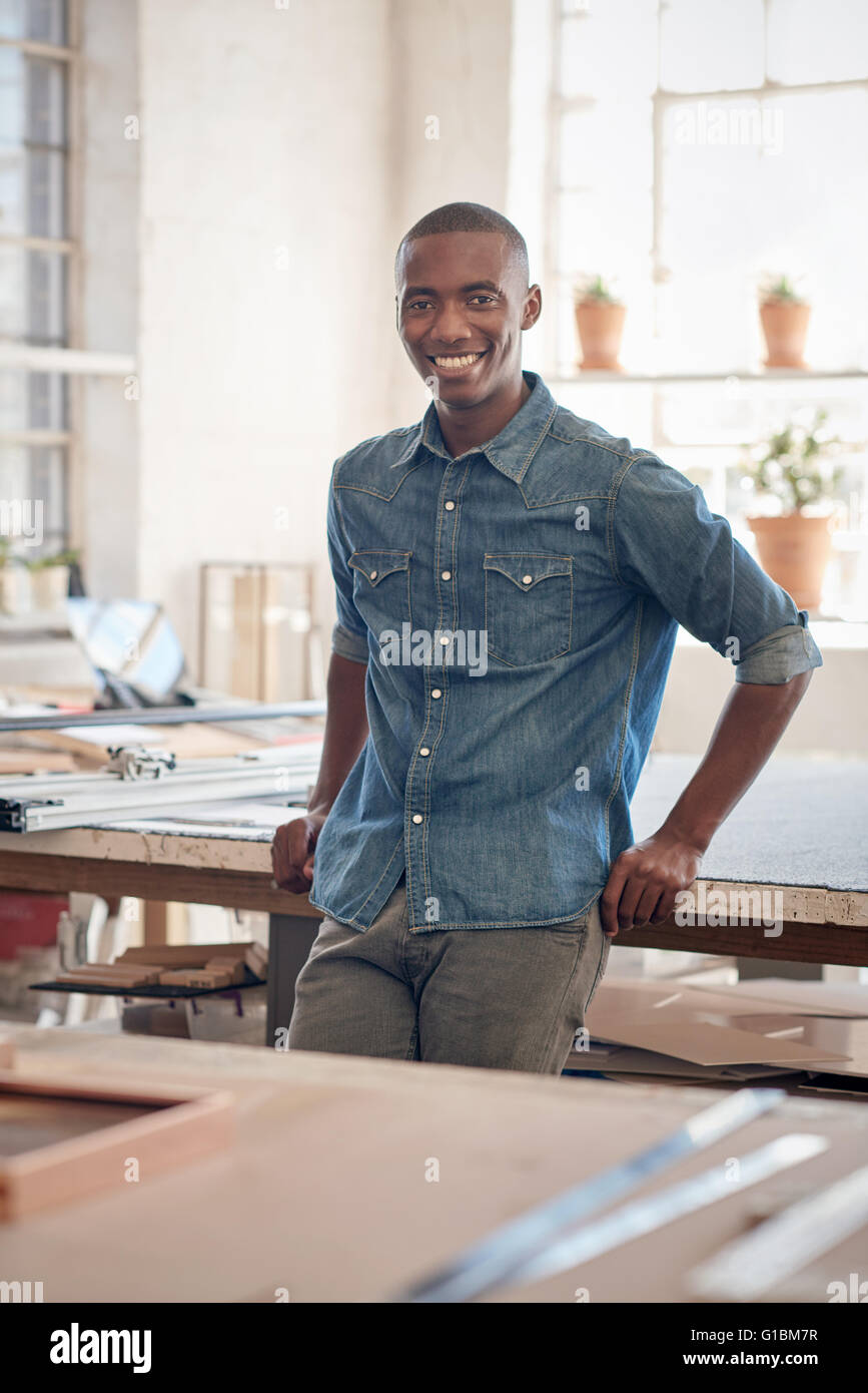 Handsome young African business owner, smiling at the camera while ...