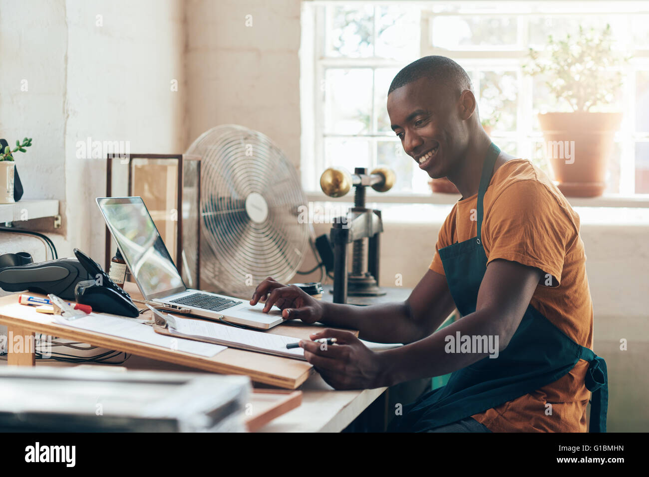 Handsome craftsman and small business owner fo African descent, sitting ...